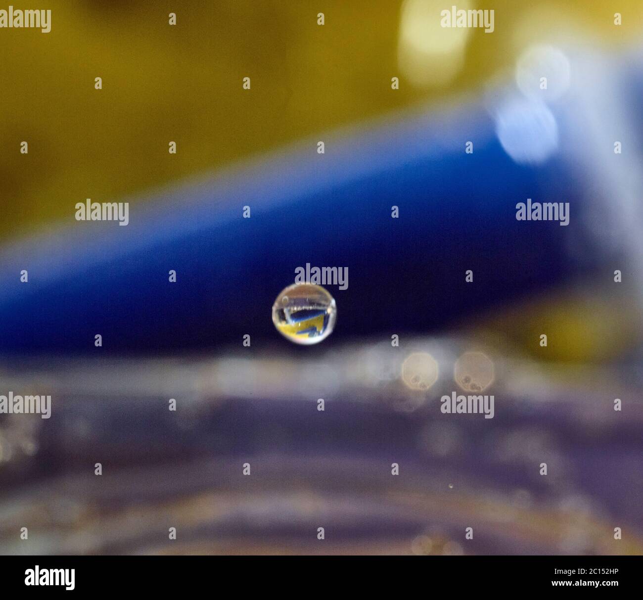 Water droplets falling on and bouncing off a pool of water, leaving ...