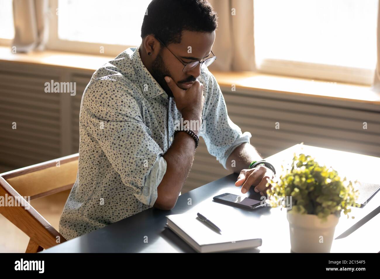 Serious African man read message on smartphone looks focused Stock ...