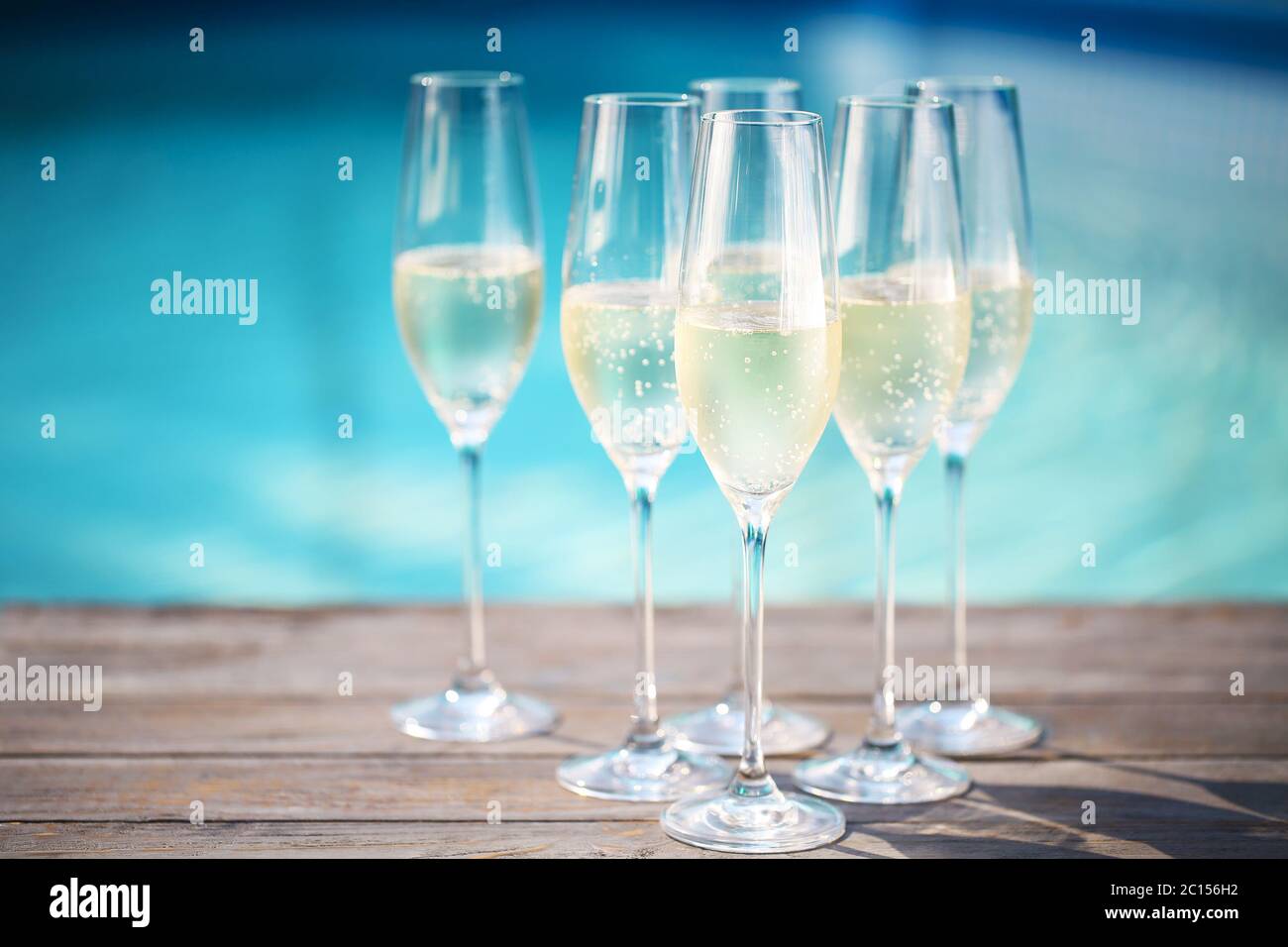 Champagne glasses on wooden background near pool Stock Photo - Alamy