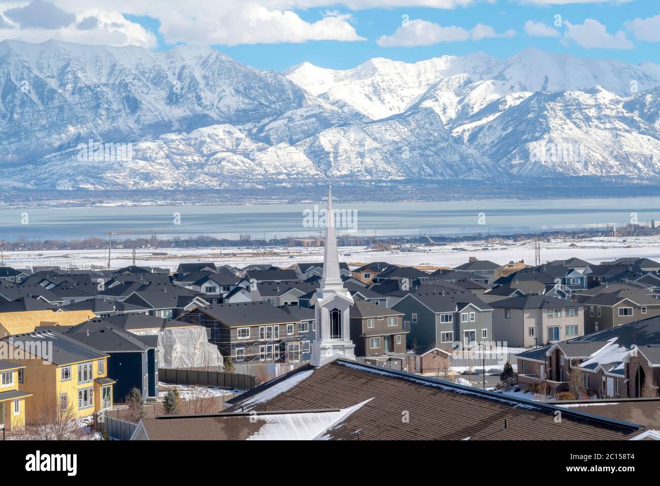 Church spire against neighborhood homes with snowy mountain and scenic ...