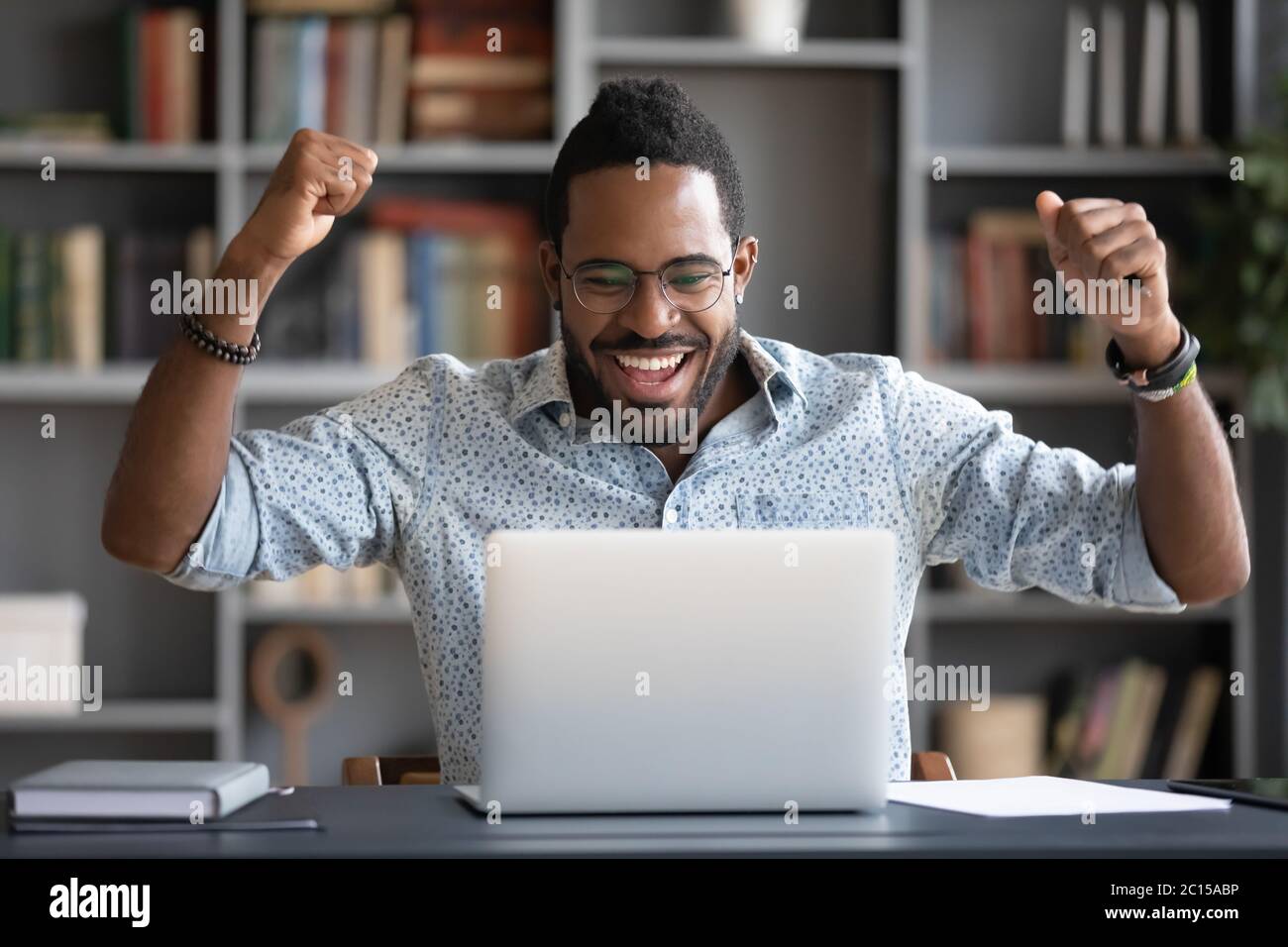 Happy african guy looking at pc screen scream with joy Stock Photo - Alamy