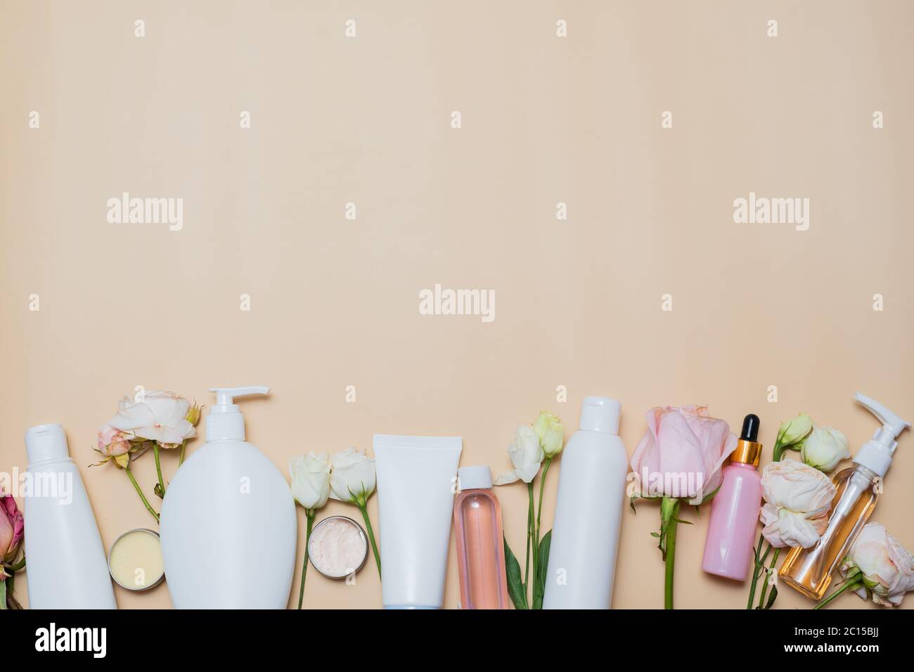 Beauty background with facial cosmetic products and flowers on pastel ...