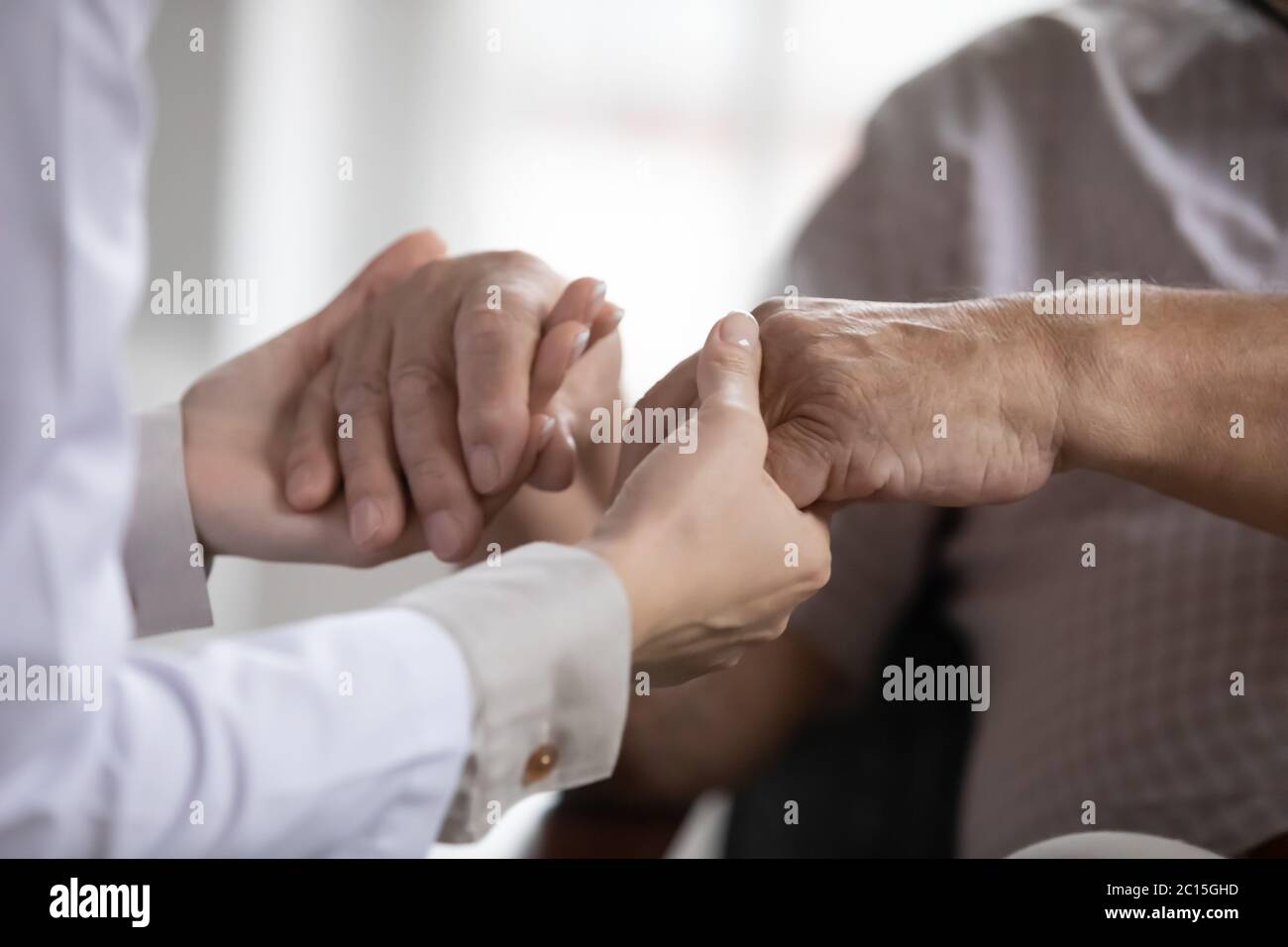 Close up caring doctor holding older man patient hands Stock Photo - Alamy