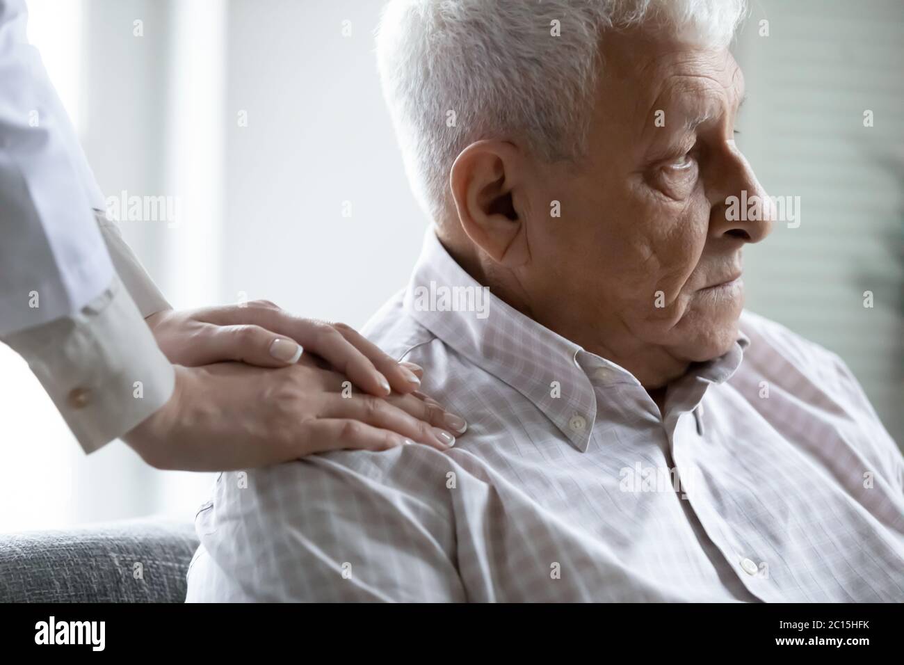 Close up caregiver supporting upset elderly man, touching patient ...