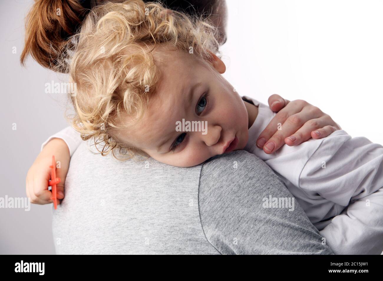 Sad child with plane on mothers hands. Warm hug from caring people ...