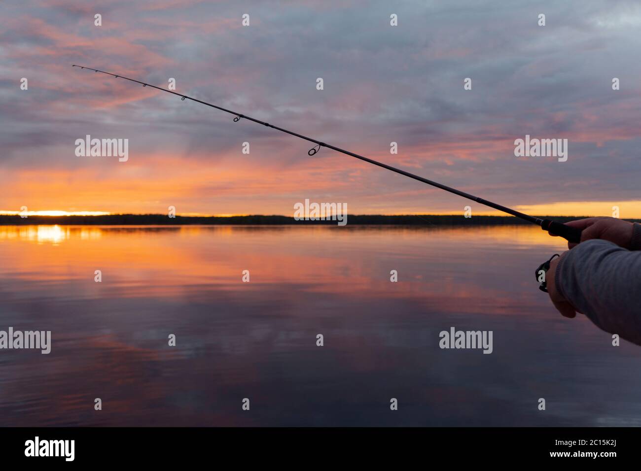Fishing on the lake at the sunset. Hands of fisherman with fishing rod ...