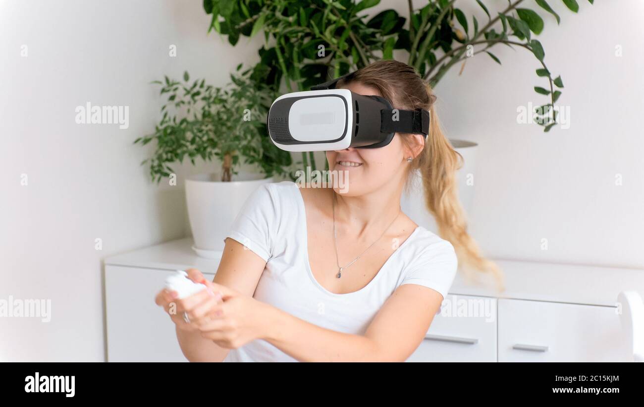 Portrait of woman in vr goggles playing 360 degree video game and using ...