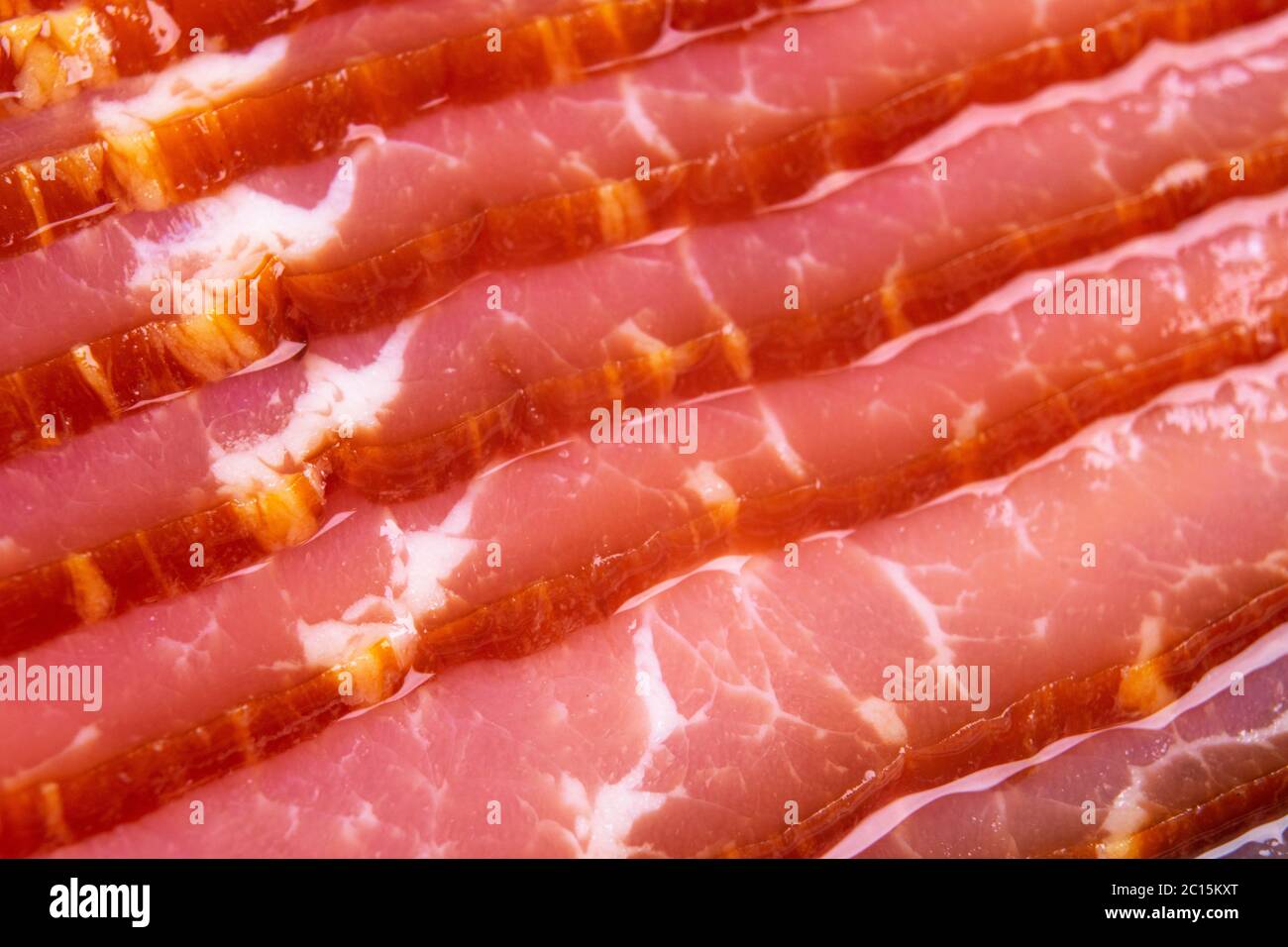 Macro shot several rows of sliced smoked bacon isolated on white ...