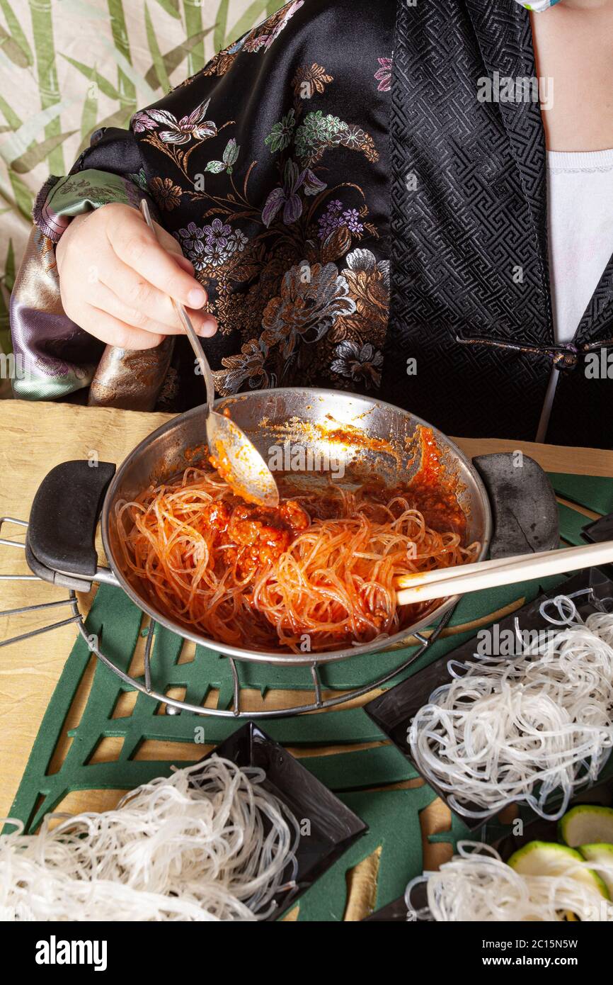 A little girl cooks Chinese noodles and Bolognese ragù, in studfio ...