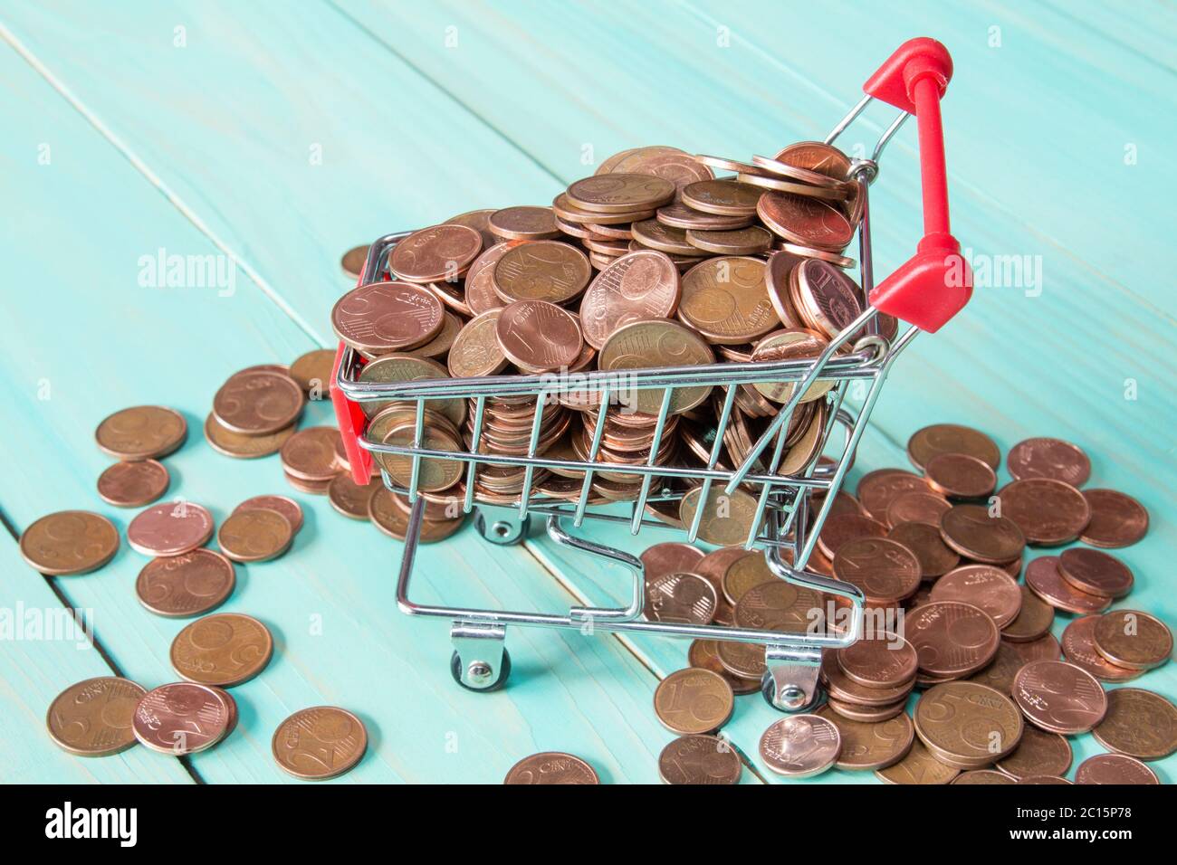 Shopping cart full of coins Stock Photo - Alamy