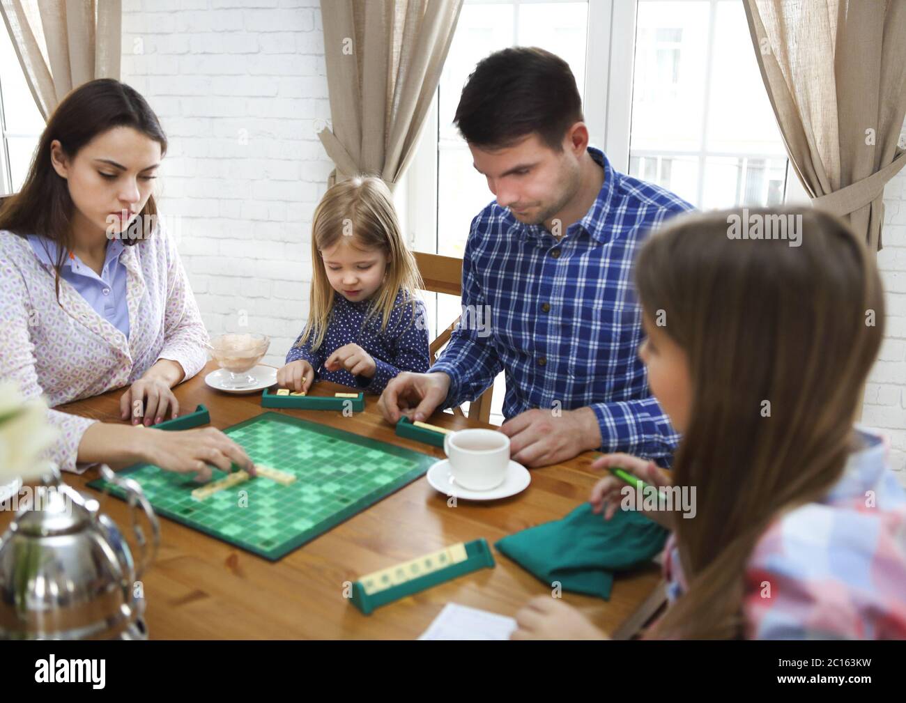 Happy young family plaing board game Stock Photo - Alamy