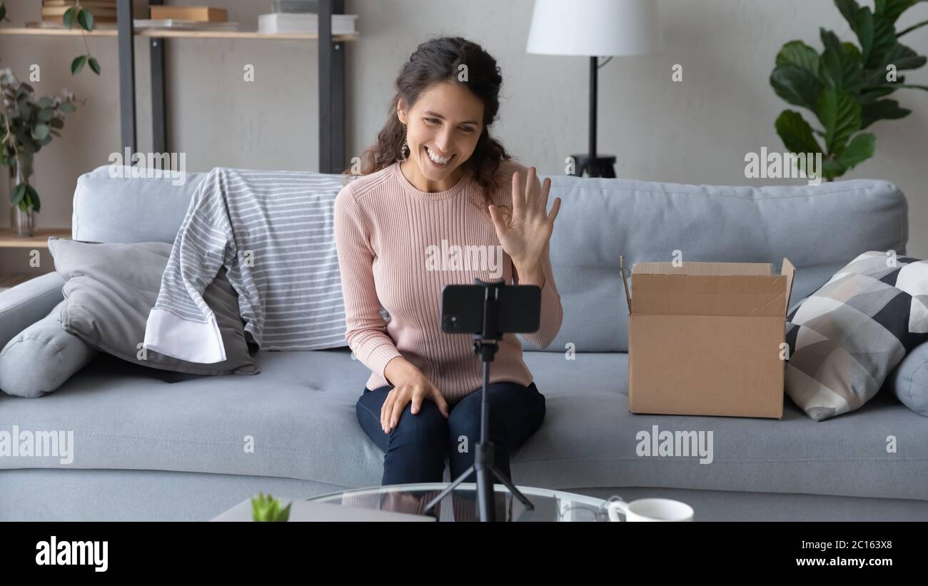 Smiling young woman shooting vlog on smartphone, waving hand Stock ...