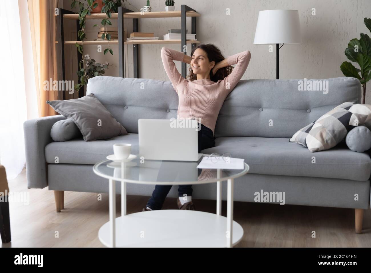 Smiling peaceful young woman relaxing, leaning back on couch Stock ...