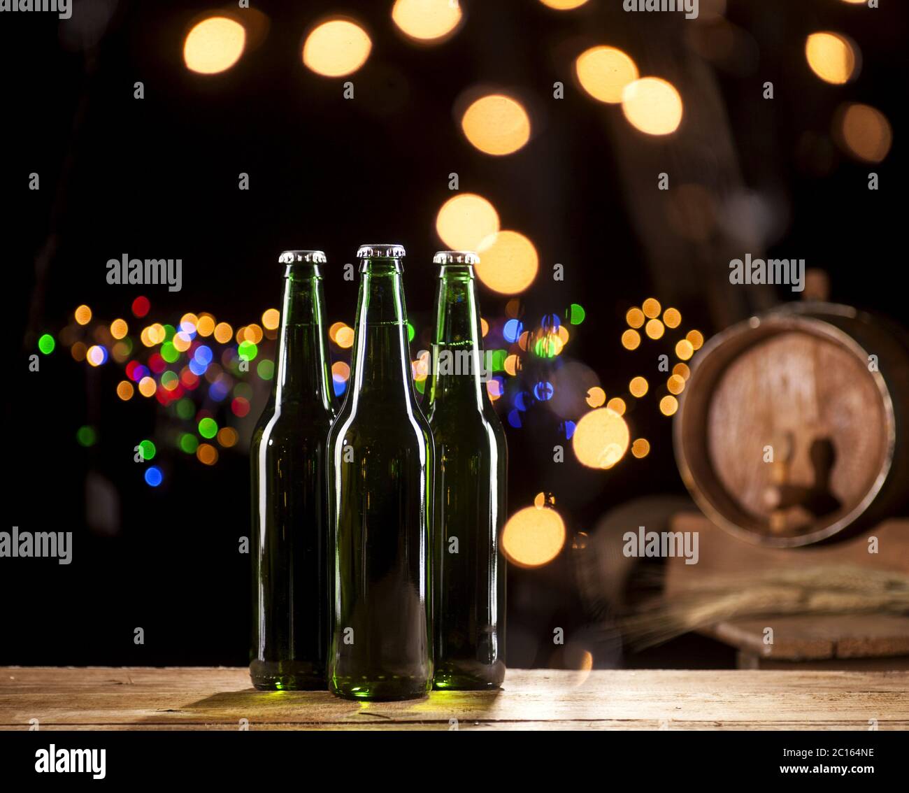 Glass bottles of beer and wooden barrel on bar lights background Stock ...