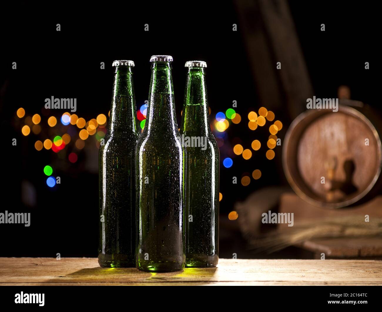 Glass bottles of beer and wooden barrel on bar lights background Stock ...
