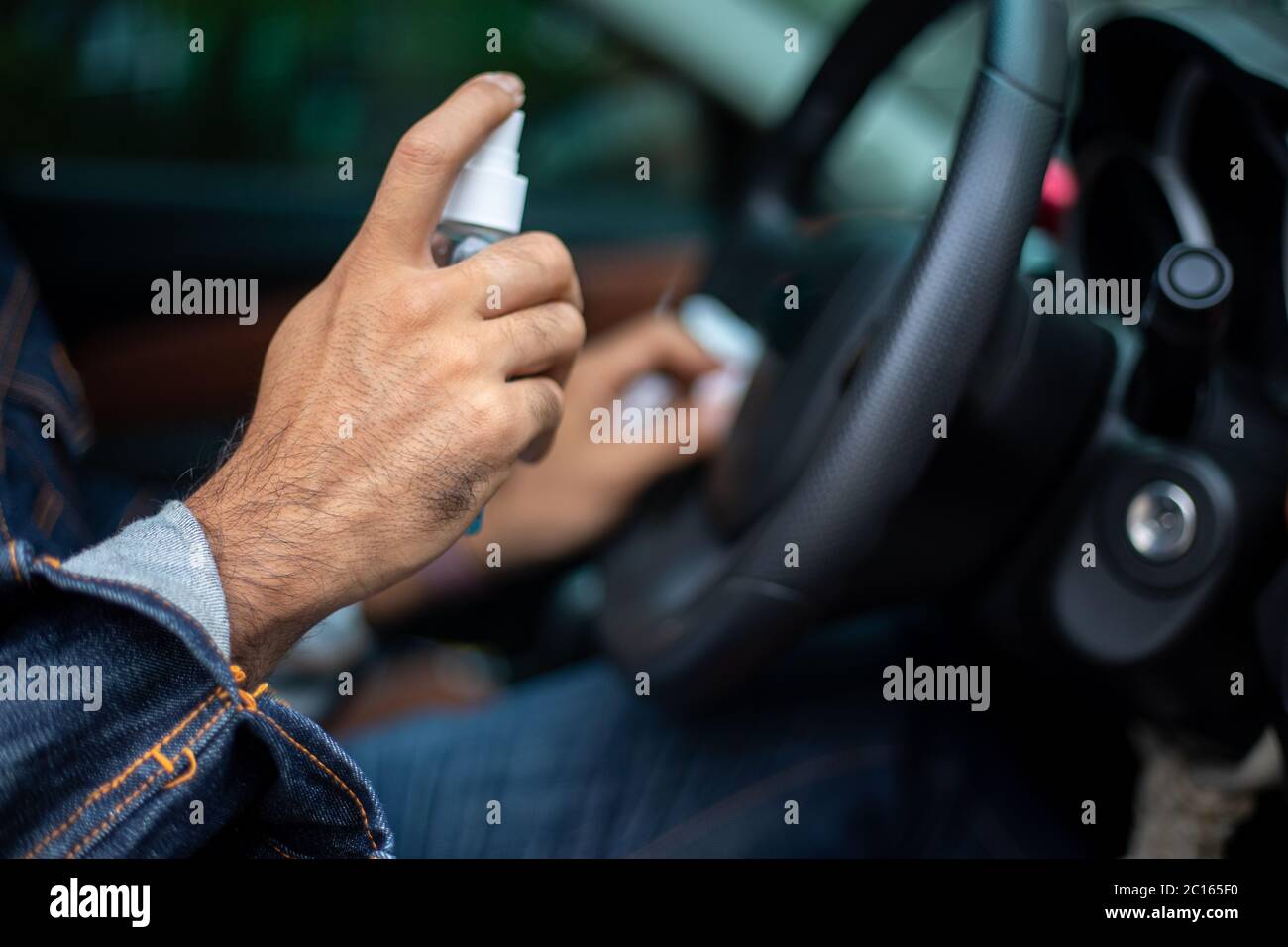 Asian man using spray alcohol to clean the car for coronavirus ...