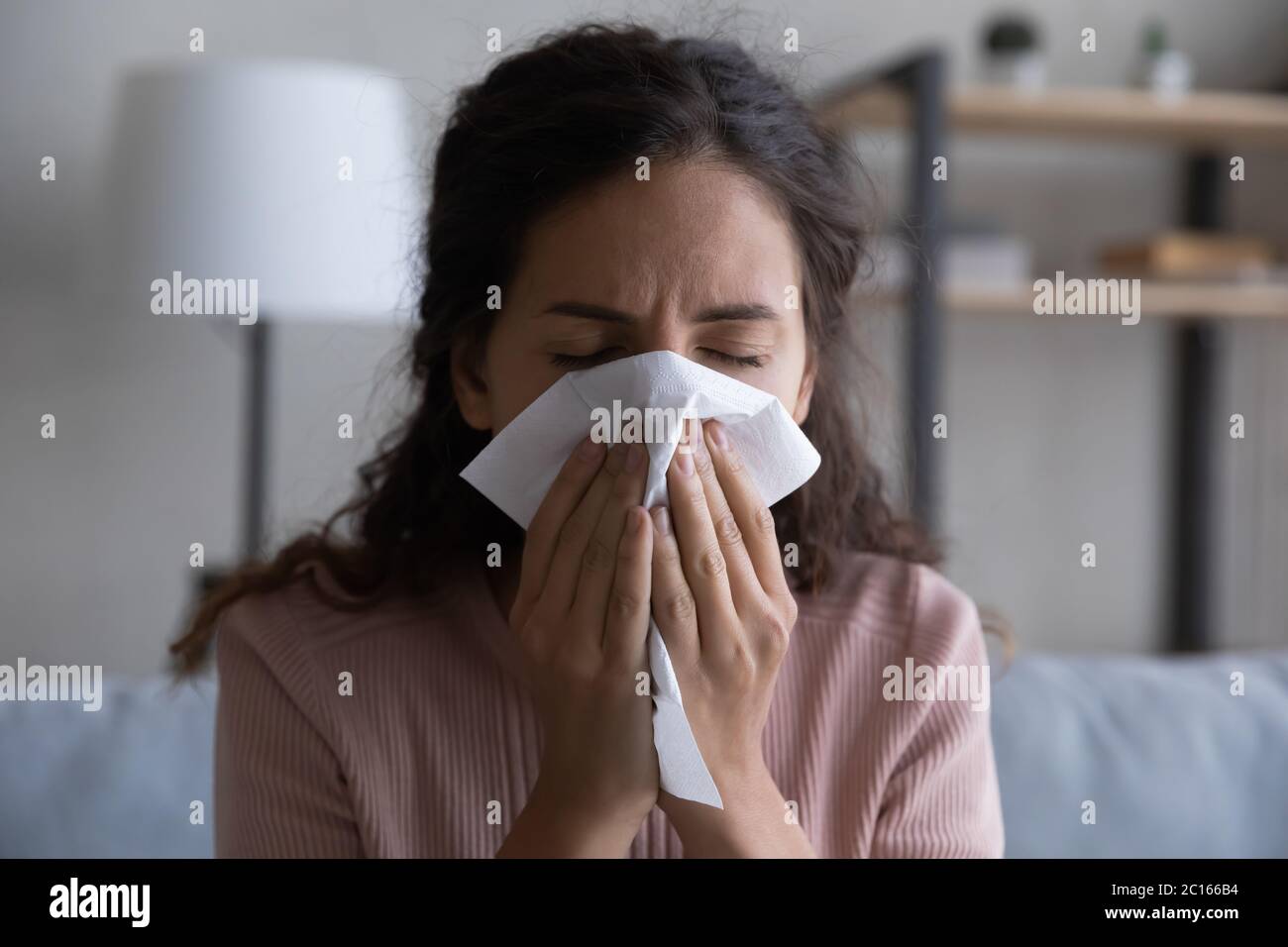 Close up sick woman blowing nose, holding paper tissue Stock Photo - Alamy