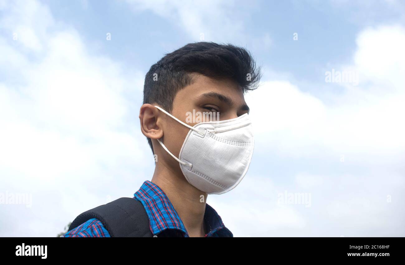 Side view of man wearing face mask on sky background Stock Photo - Alamy