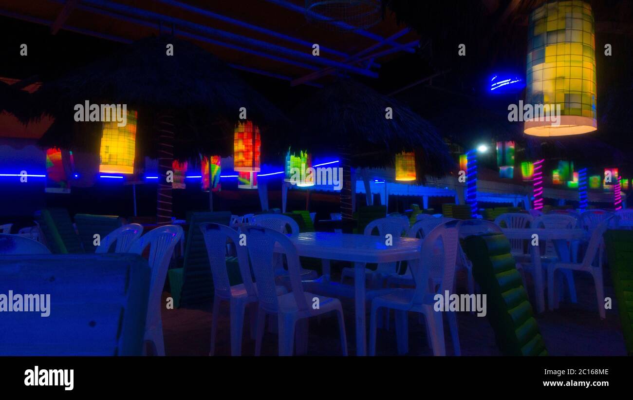 Plastic tables inside an empty disco bar with blue lights near the ...