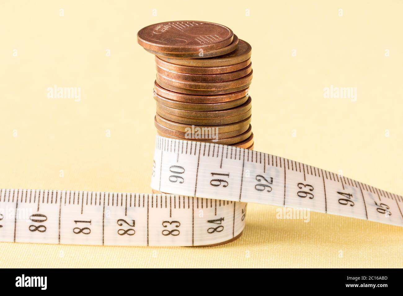 Coins and measurement tape Stock Photo - Alamy