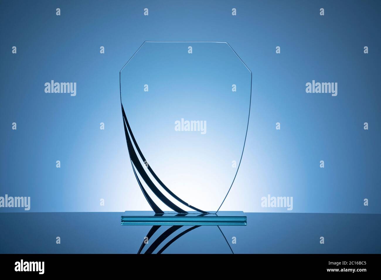 Elegant blank glass shield trophy on dark blue background ready to be ...