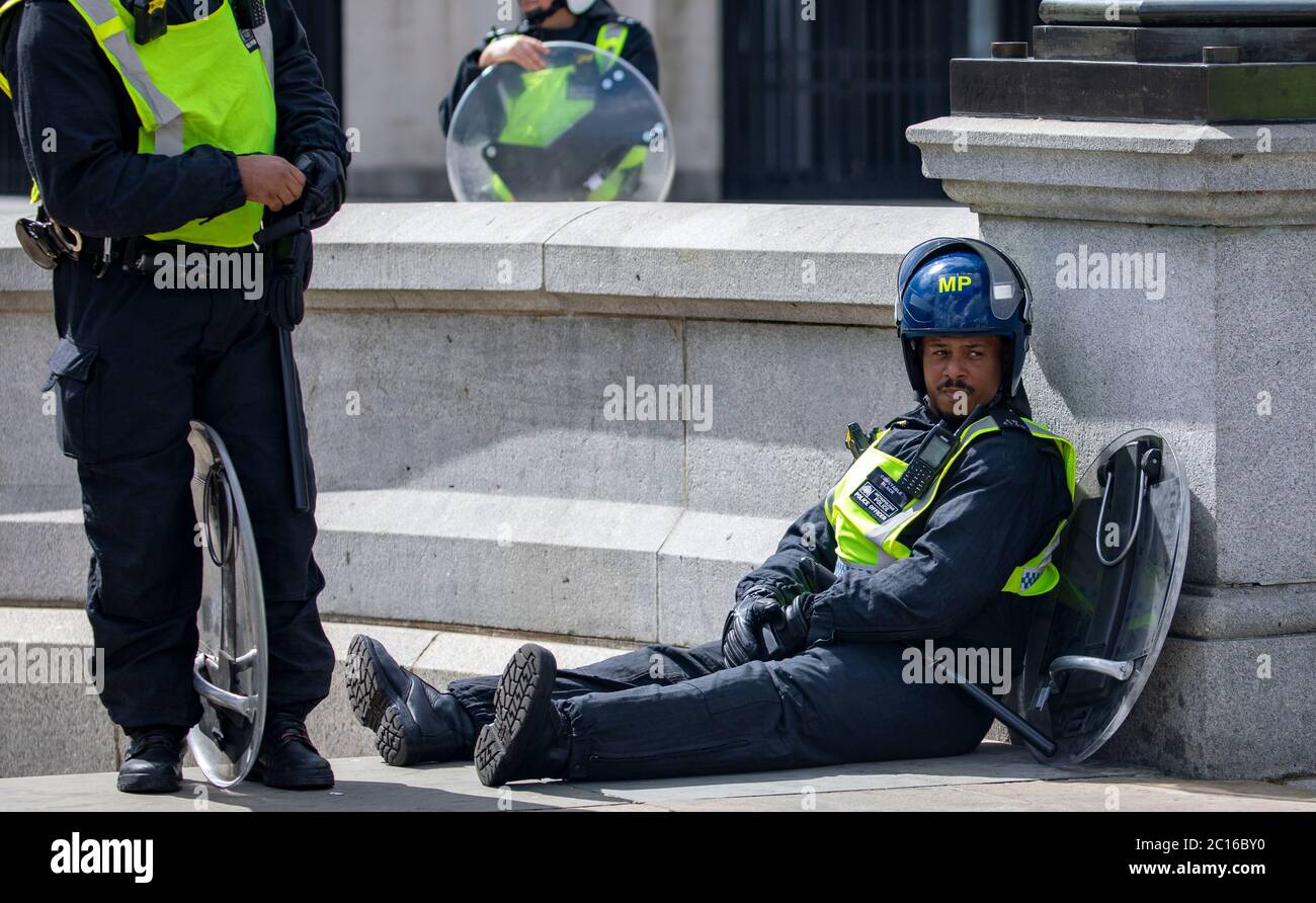 pic shows: Constable Black Exhausted riot cop takes a breather after ...
