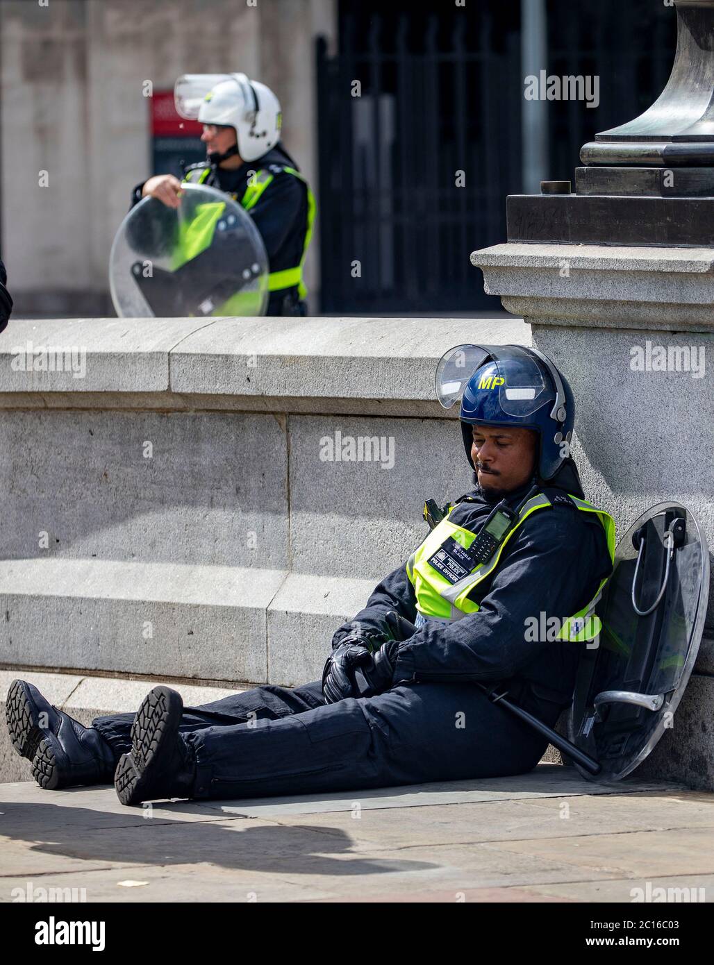 pic shows: Constable Black Exhausted riot cop takes a breather after ...
