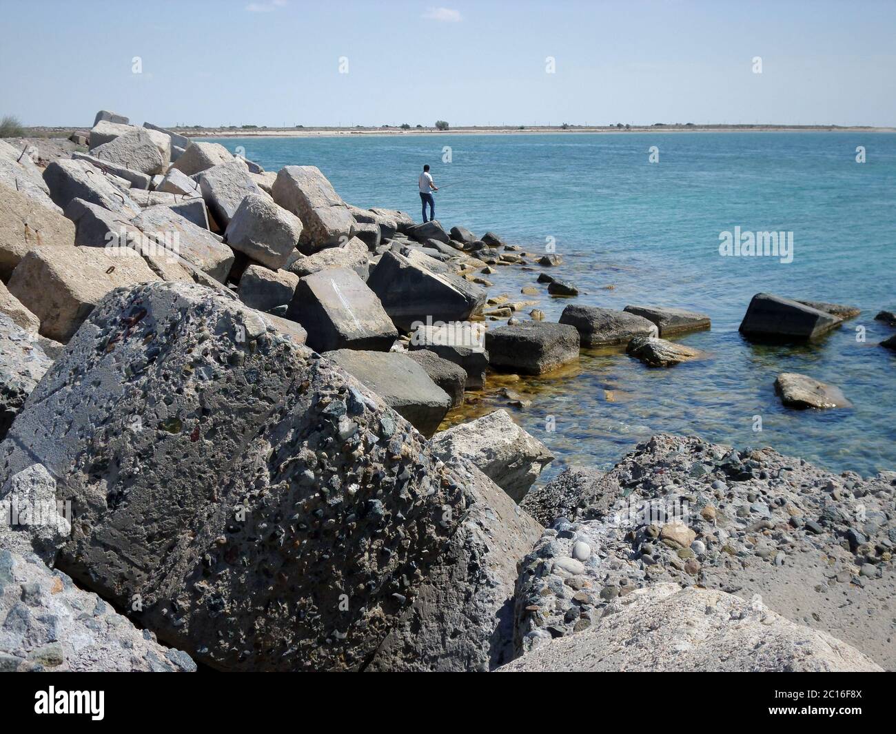 Fisherman on the shore of the Caspian Sea. Water intake channel for the ...