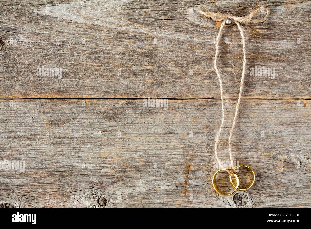 Wedding rings hanging on wooden wall Stock Photo - Alamy