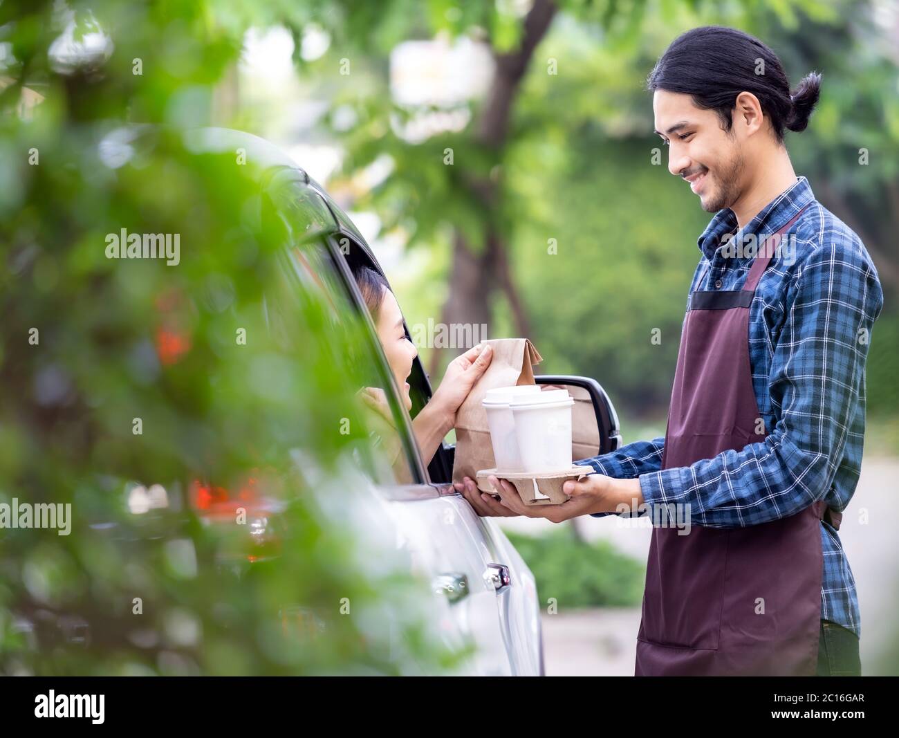 Waiter giving hot coffee cup with disposable tray and bakery bag ...