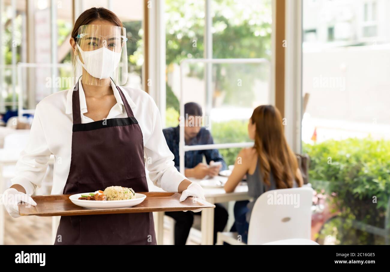 Portrait attractive asian waitress wear face mask and face shield ...
