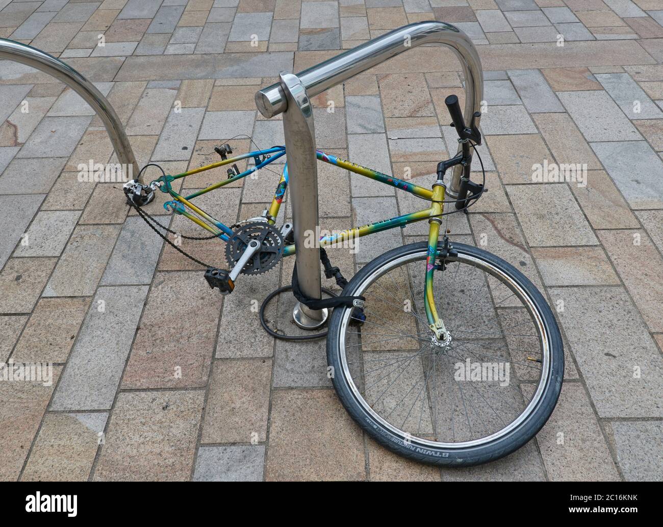 Bicycle without rear wheel lying on ground and chained to bicycle ...