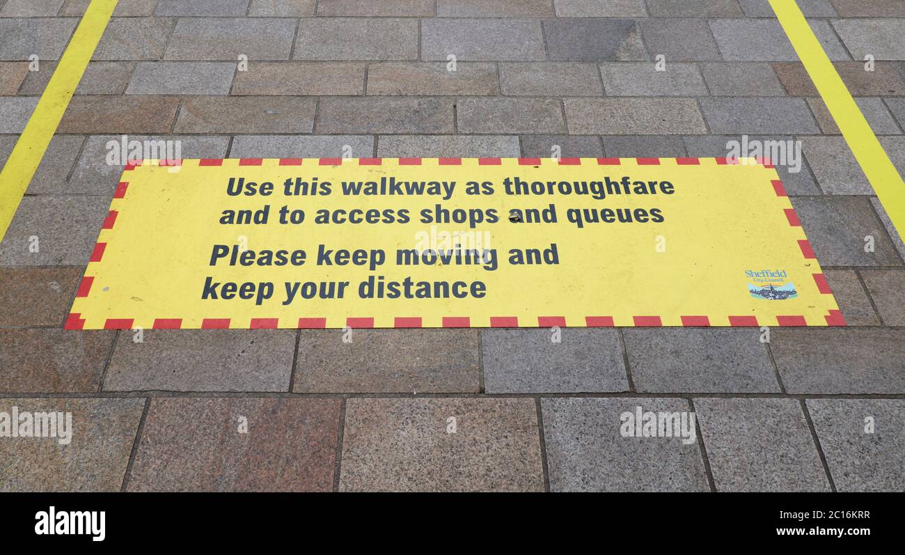 Signs and stickers on pavement to guide pedestrians along ...