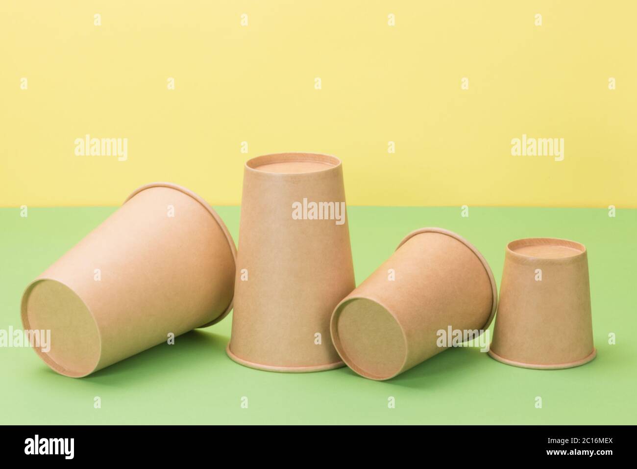 Paper cups in the green and yellow background. Environmental disposable ...