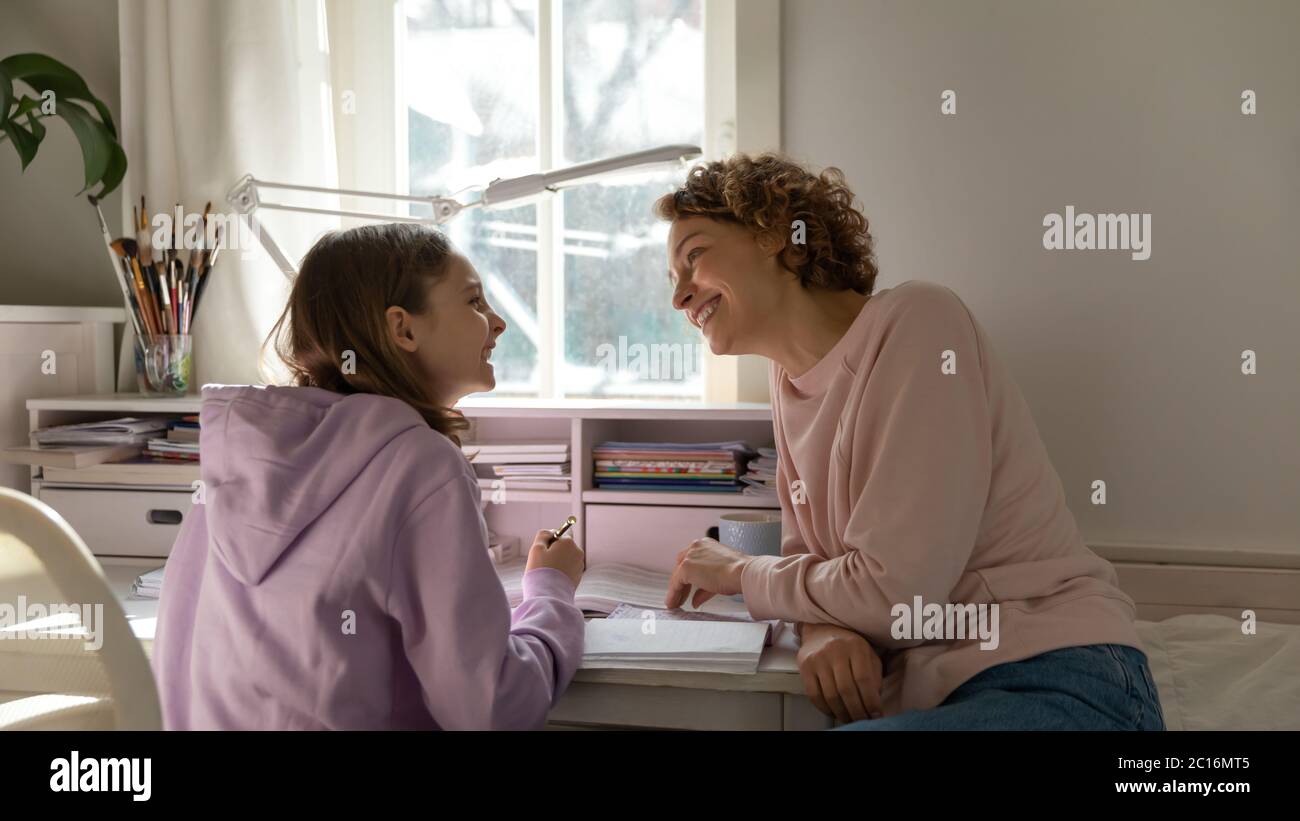 Smiling loving mom and teenage daughter do homework together Stock ...