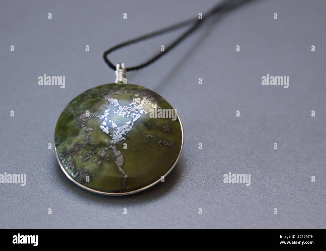 Single peruvian jade stone in handmade jewelry on grey background Stock ...