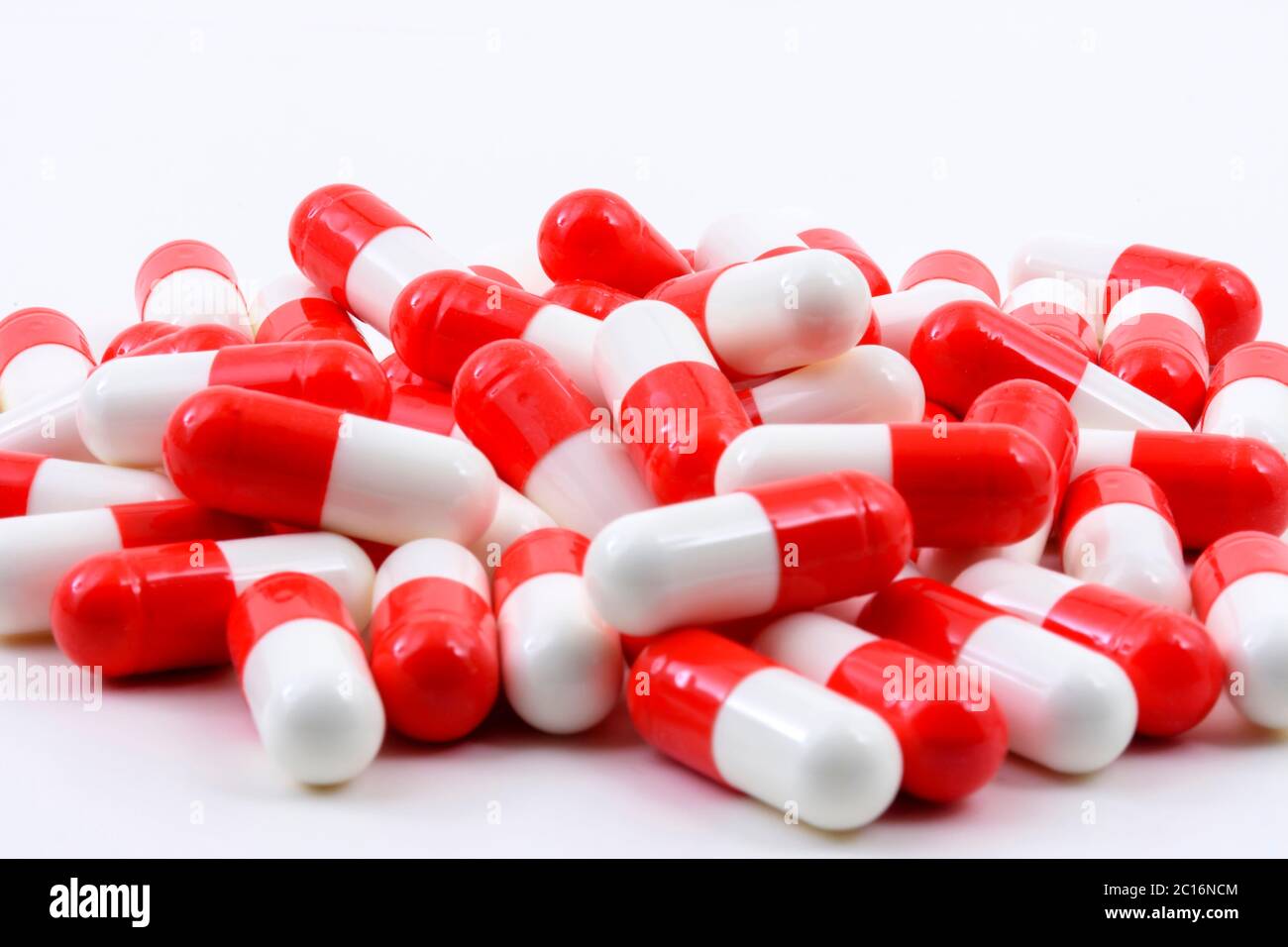 Several red and white pills of medicine on white background with free ...