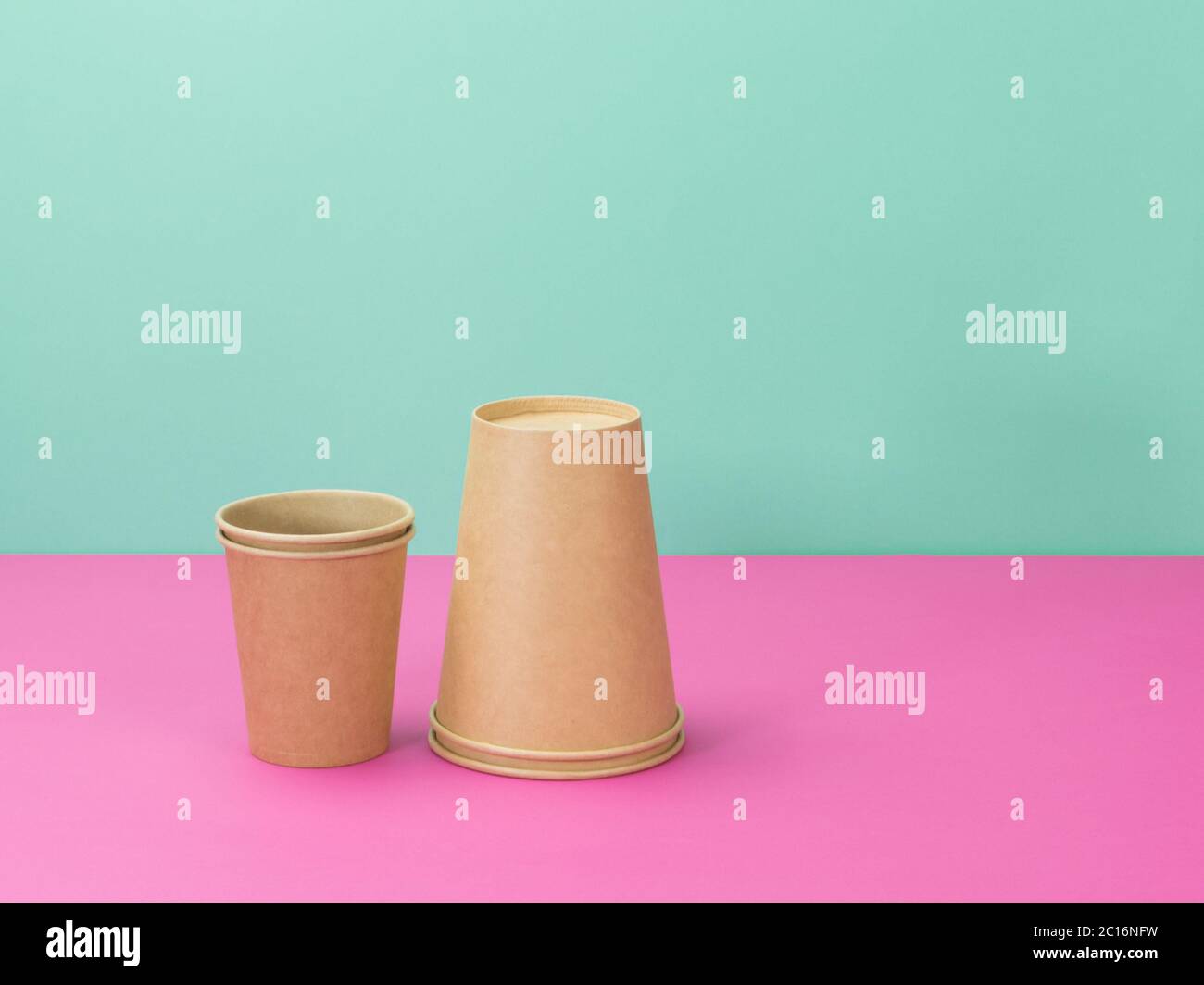Disposable paper cups on a pink and turquoise background. Accessories ...