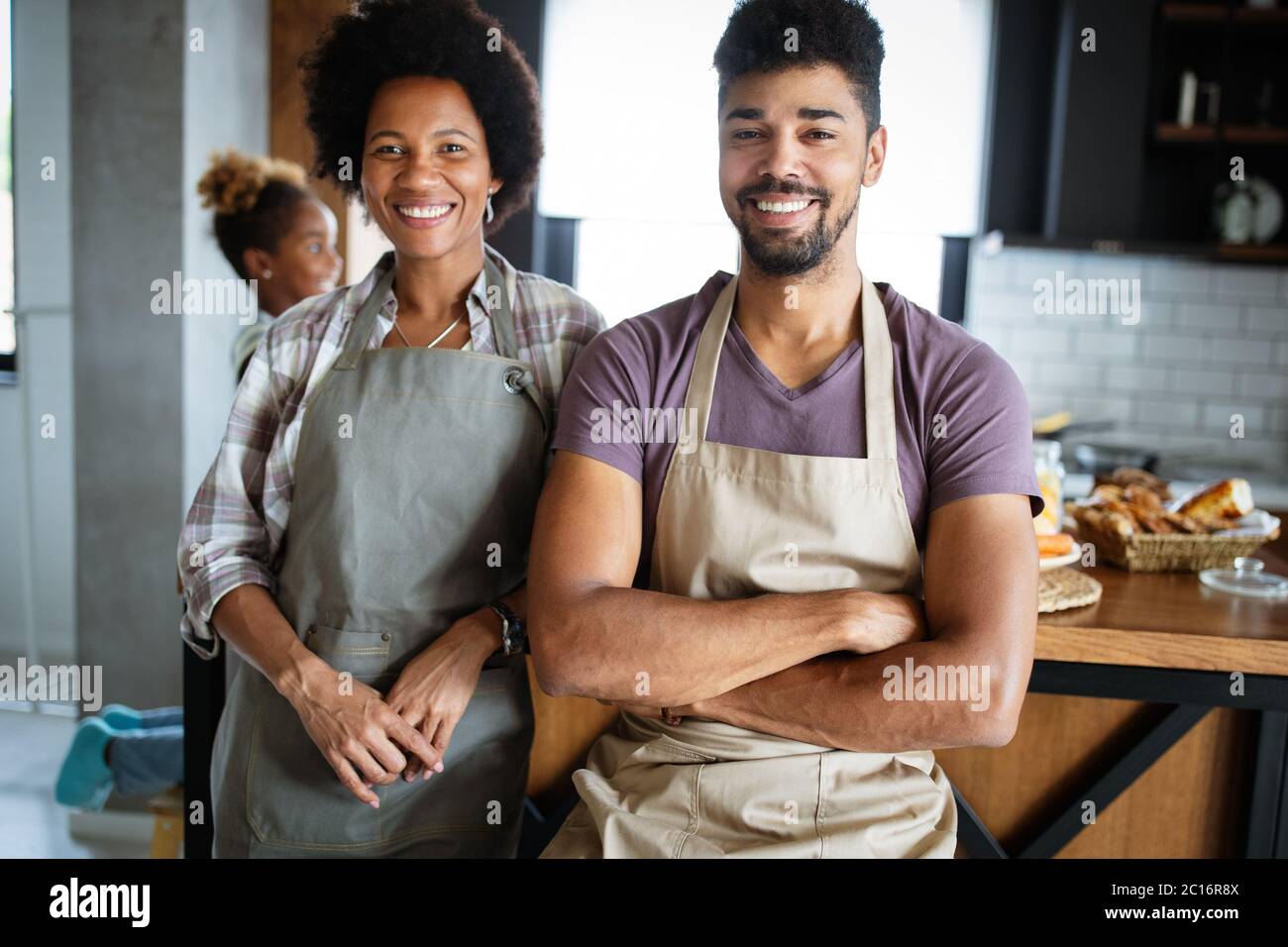 Beautiful young couple having fun and laughing while cooking in kitchen ...