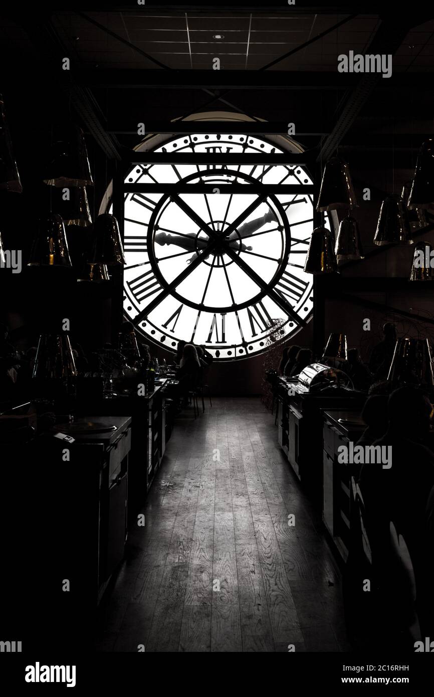 inside orsay museum and there is a big clock two people stand beside ...