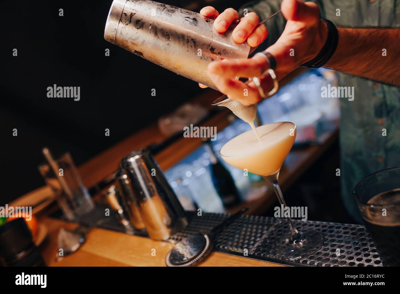 Bartender pouring using strainer White healthy Cocktail drink on a bar ...