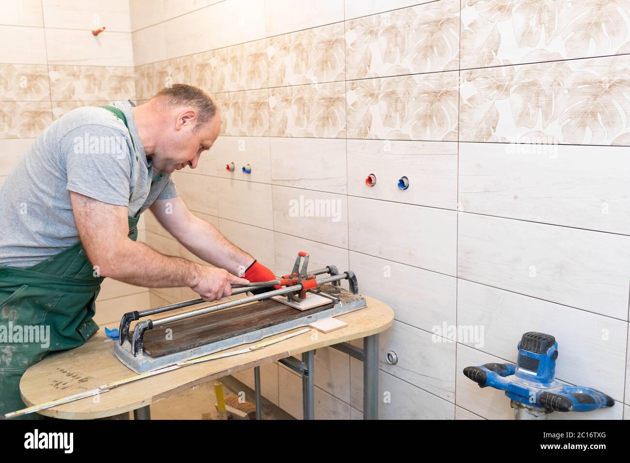 Tile cutting machine. Construction worker. Precise cutting of ceramic ...