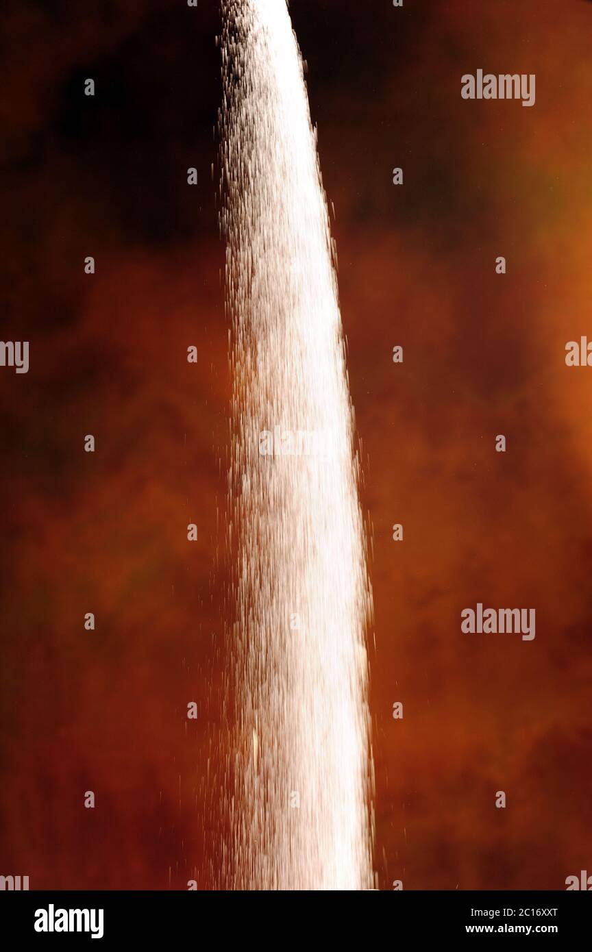 Sugar pouring in a straight line. Vertical photo with copy space to the ...