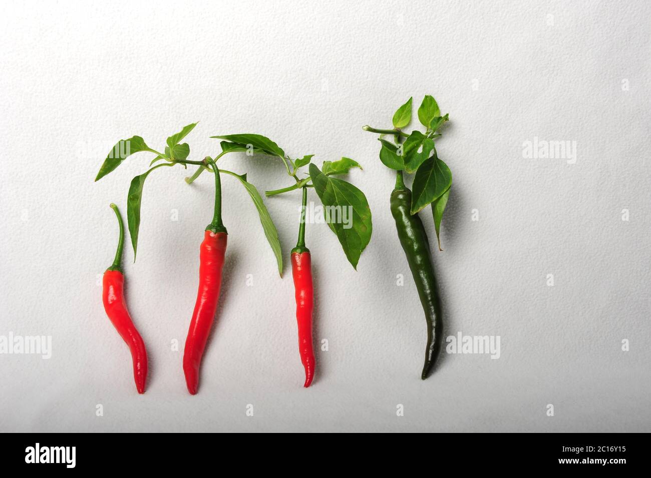 Three Red and One Green Chilis Stock Photo - Alamy