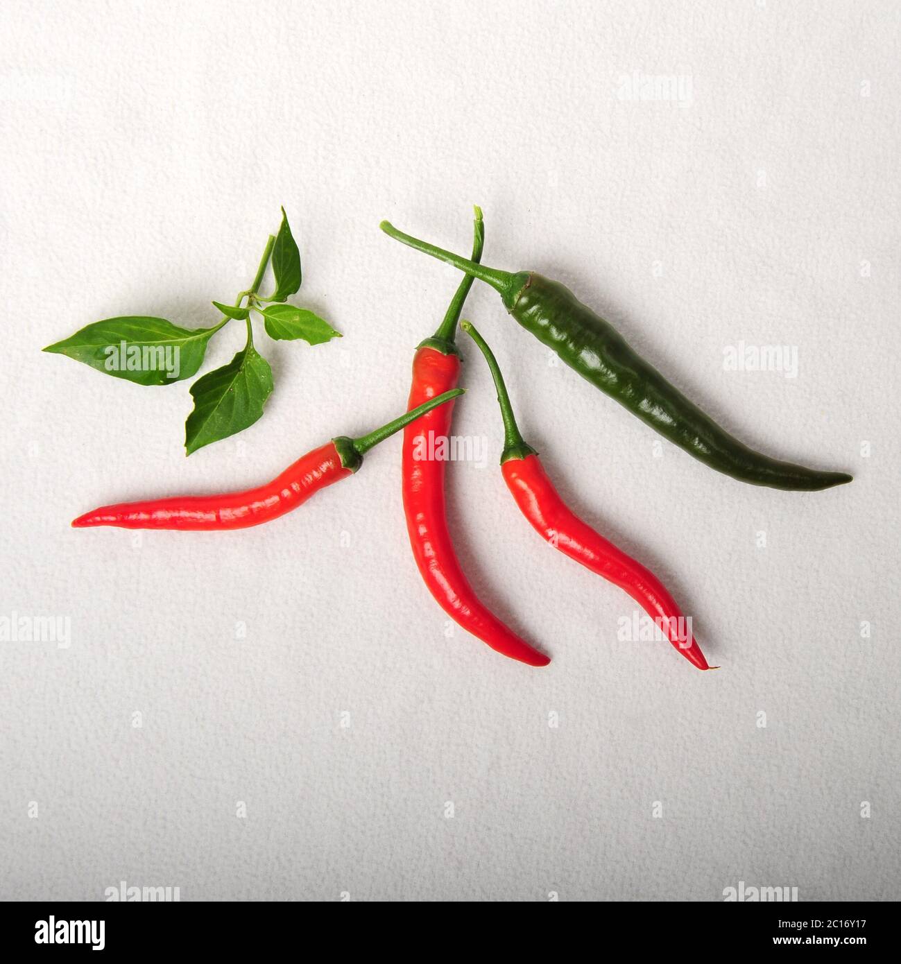 Three Red and One Green Chilis Stock Photo - Alamy