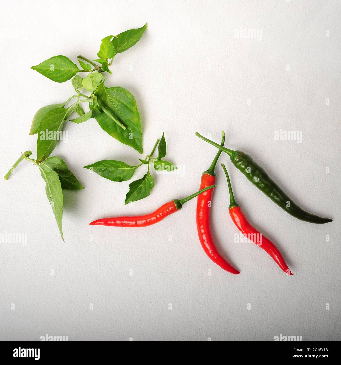 Three Red and One Green Chilis Stock Photo - Alamy
