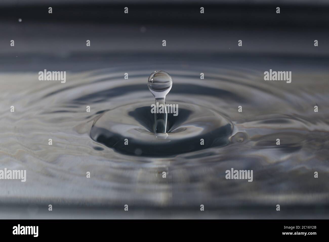 A small water drop fall on water surface Stock Photo - Alamy