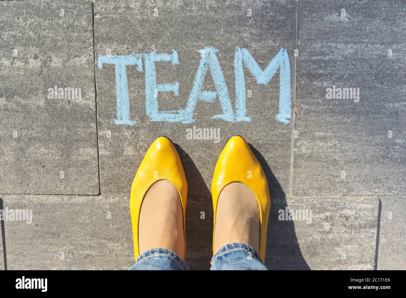 Team concept, top view on woman legs and text written in chalk on gray ...
