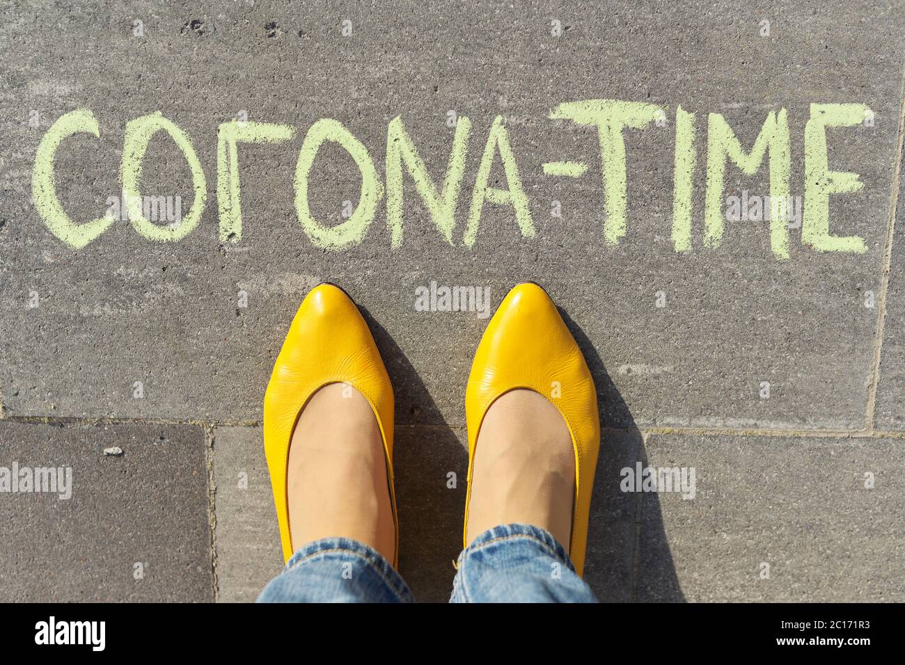 Corona time concept, top view on woman legs and text written in chalk ...