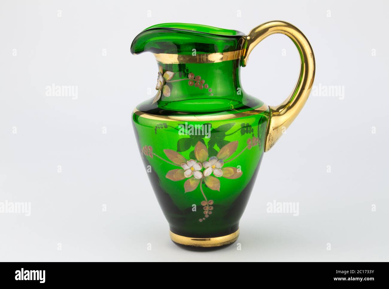 Vintage green and gold glass hand blown milk jug isolated on white ...